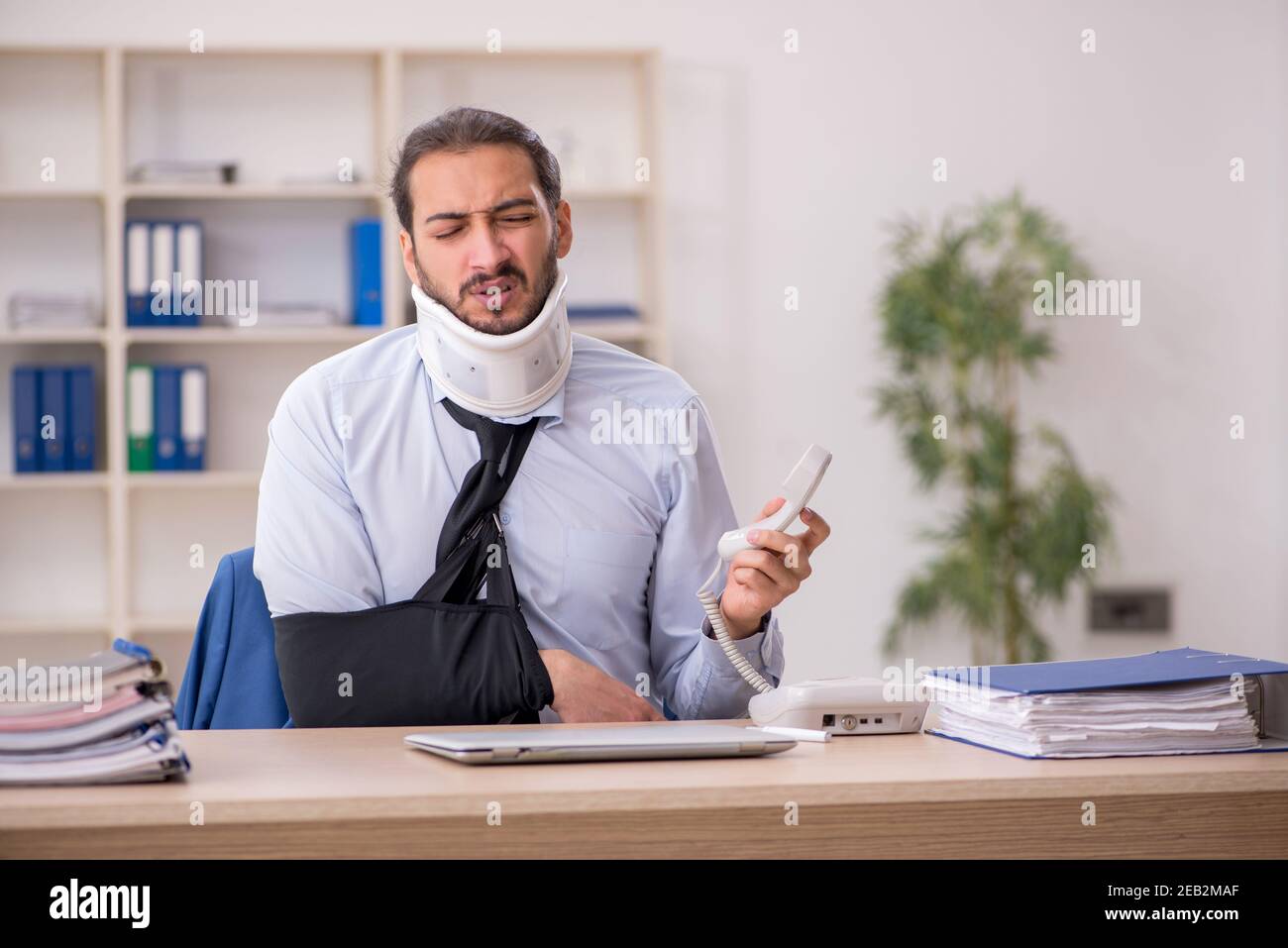 Young man employee after accident working in the office Stock Photo - Alamy