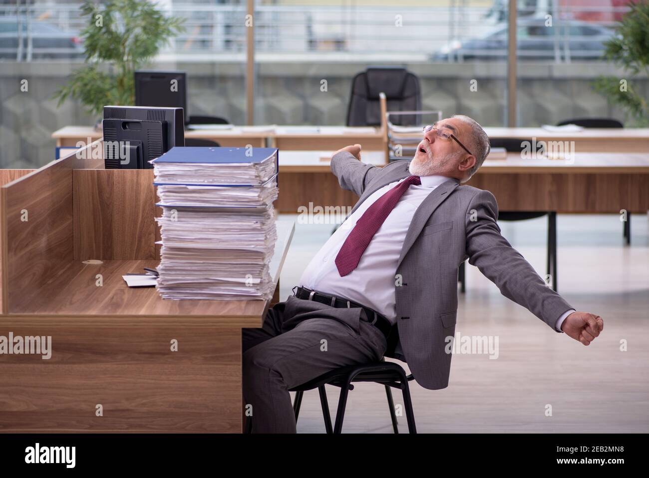 Old male employee and too much work in the office Stock Photo - Alamy