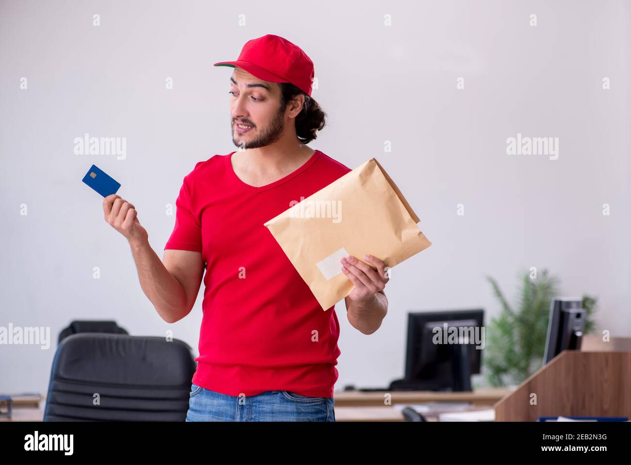 Young courier delivering post to the office Stock Photo - Alamy