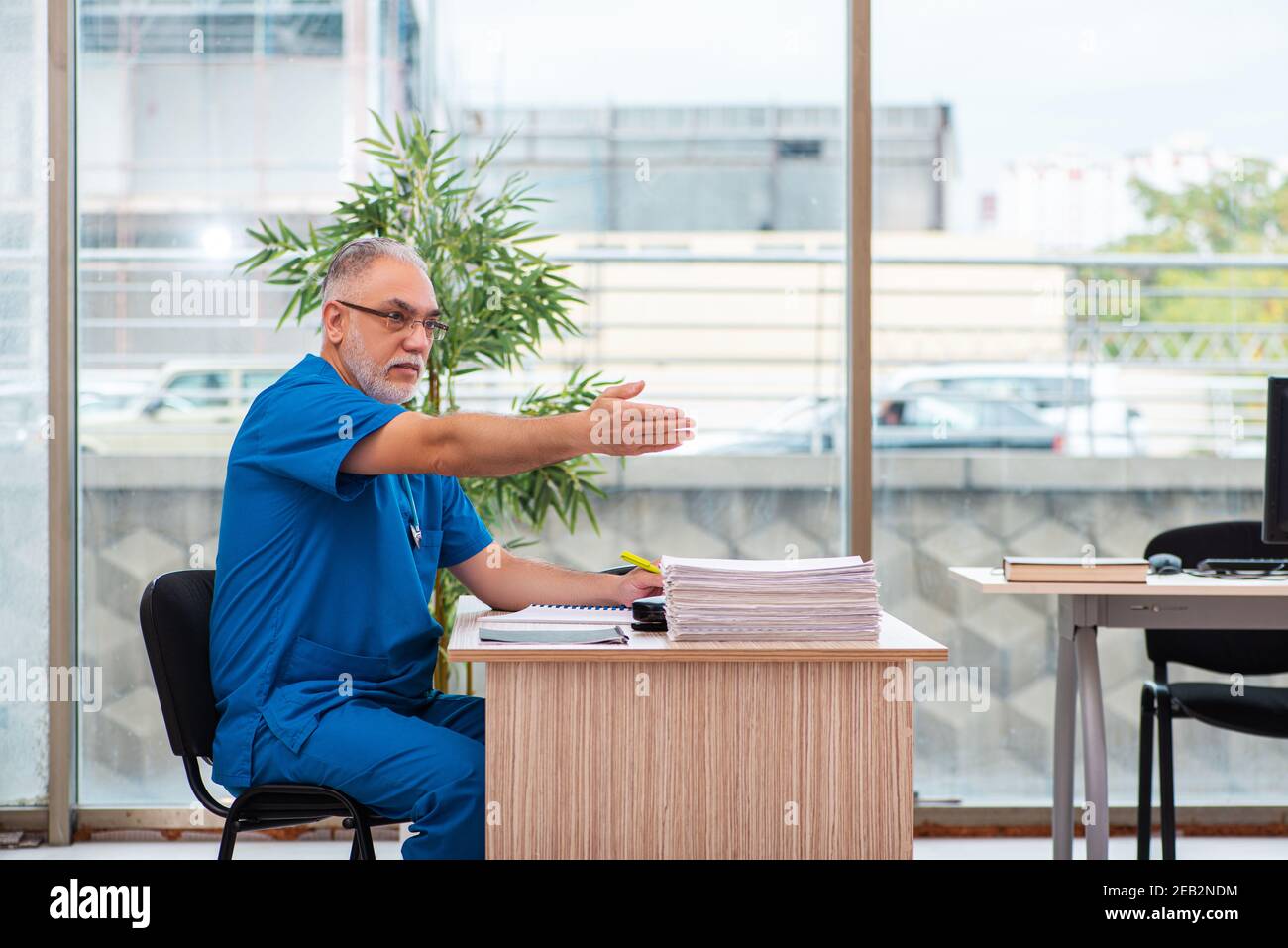 Old doctor working in the clinic Stock Photo - Alamy