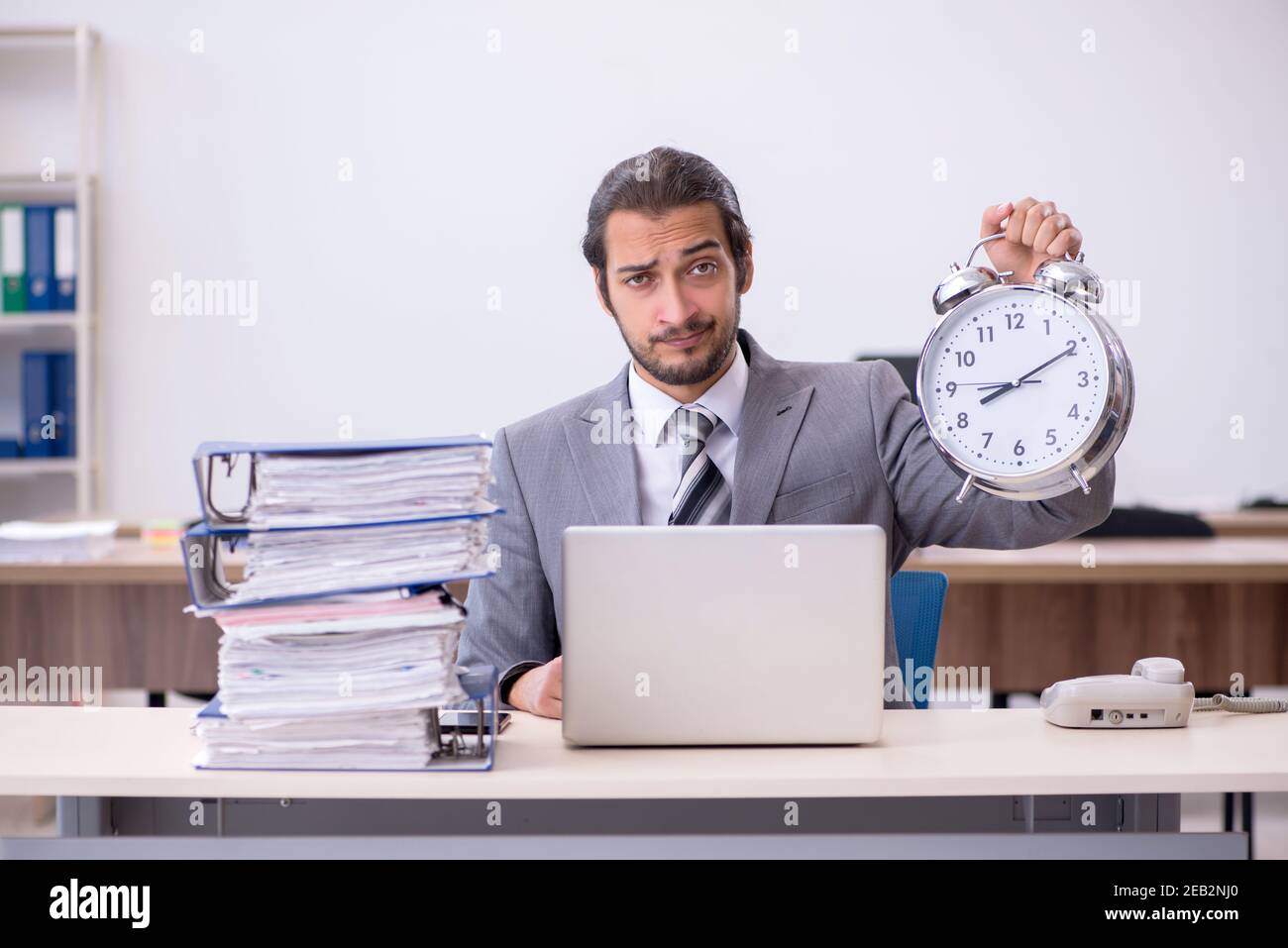 Young employee in time management concept Stock Photo - Alamy