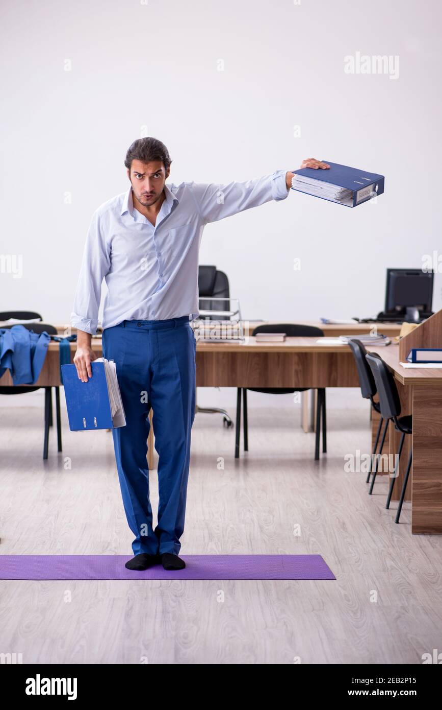 Young employee doing sport exercises during break Stock Photo - Alamy