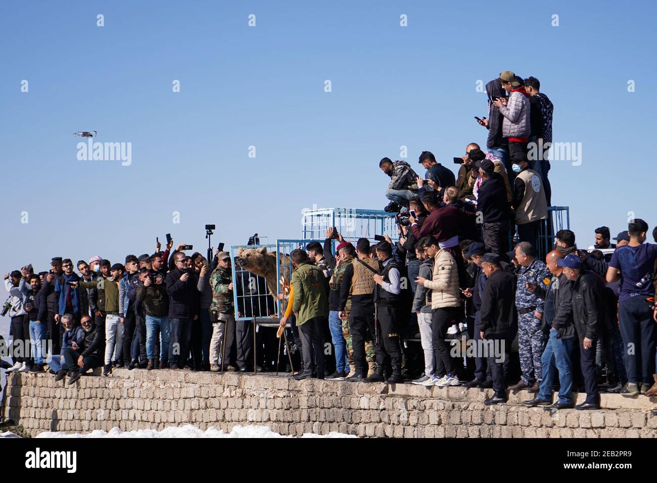 Duhok, Iraq. 11th Feb, 2021. A group of people watch as the bear comes ...