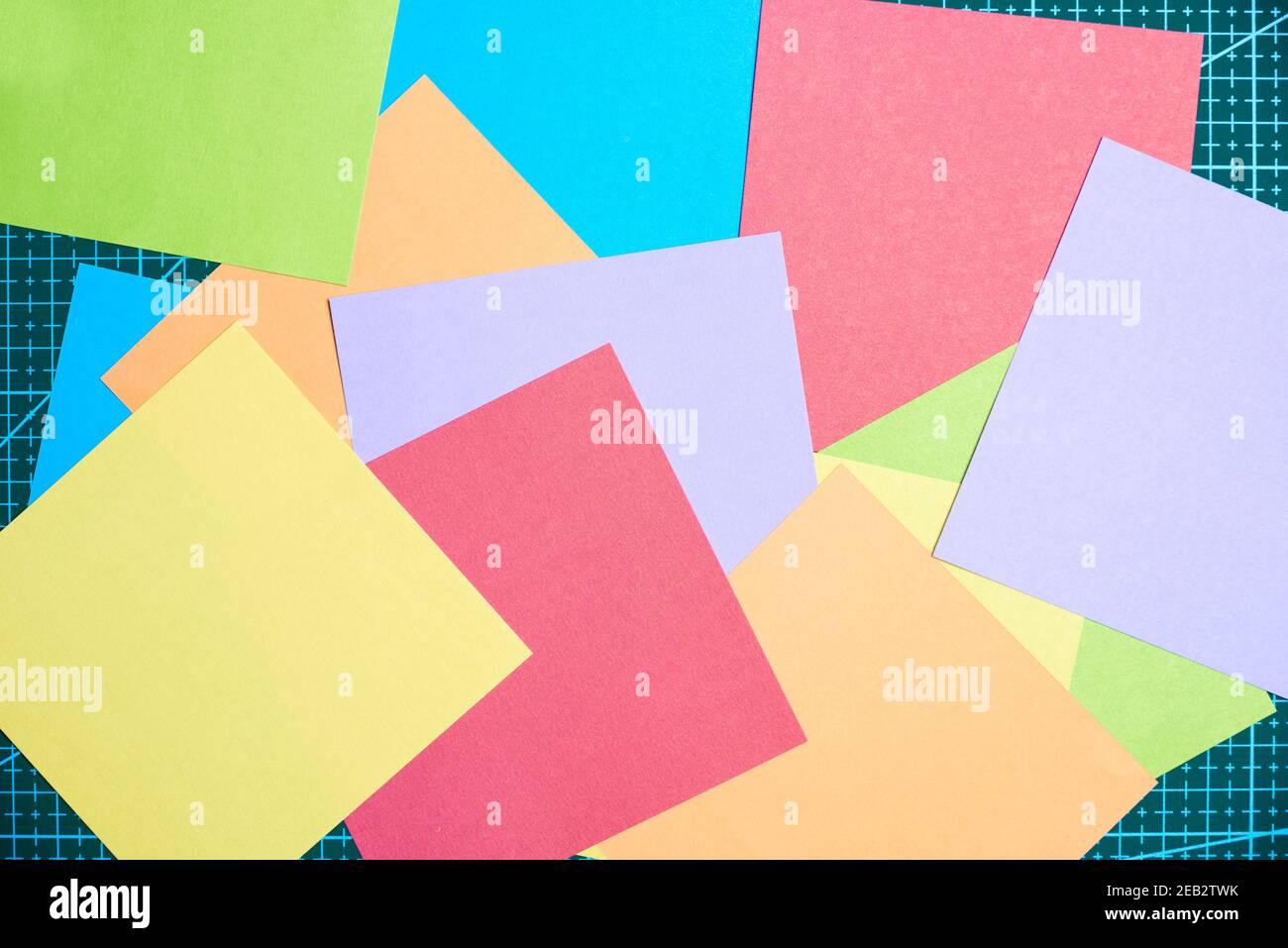Colorful paper squares on a cutting board. Supplies for origami or ...