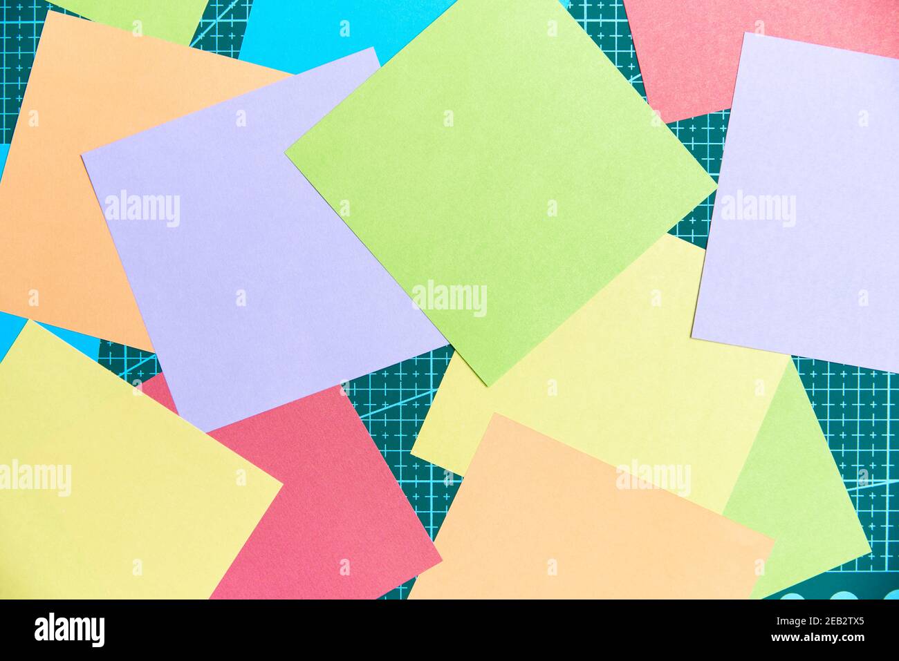 Colorful paper squares on a cutting board. Supplies for origami or ...