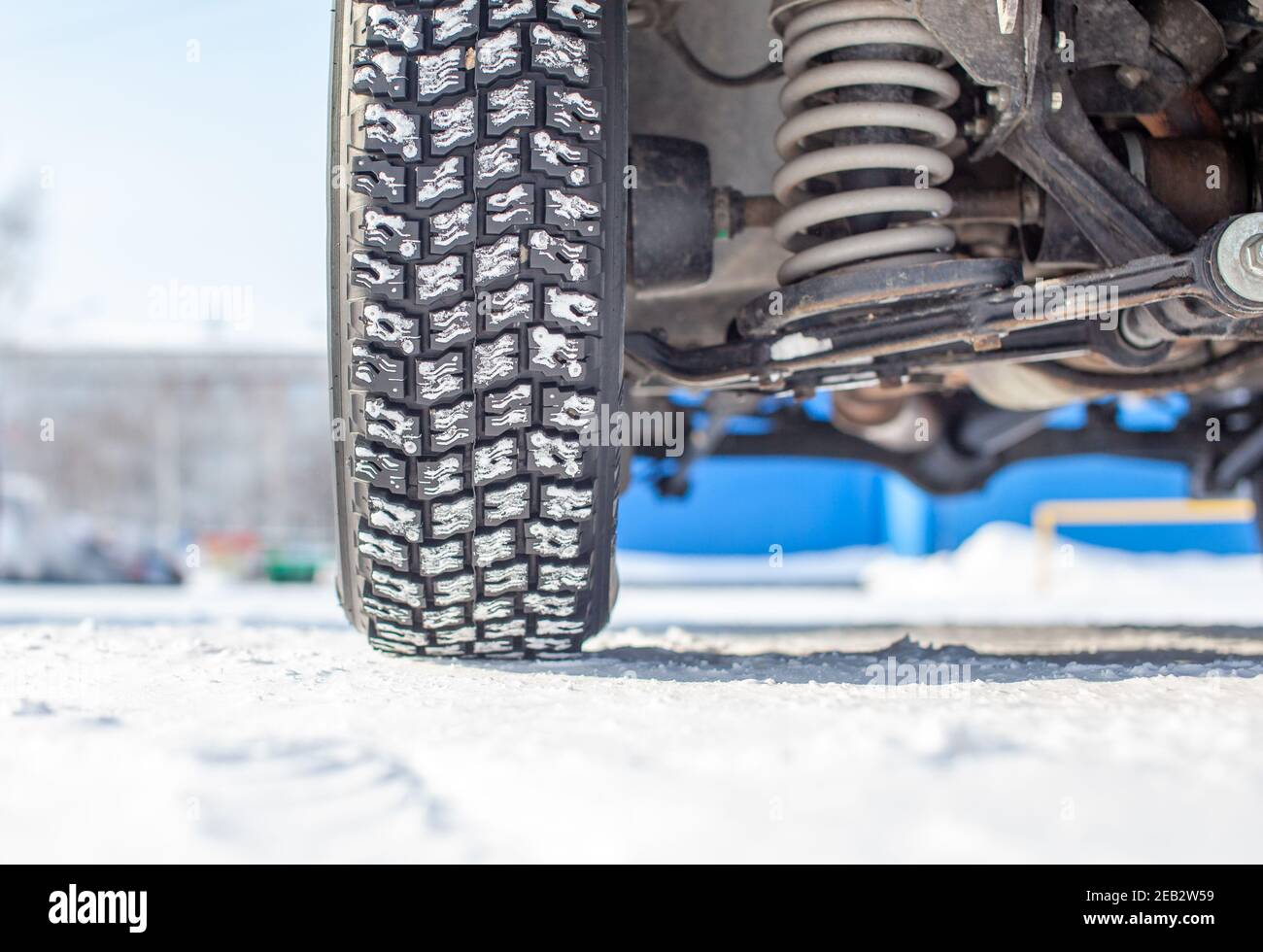 Car wheel on snow in winter close-up. The suspension and chassis of the ...