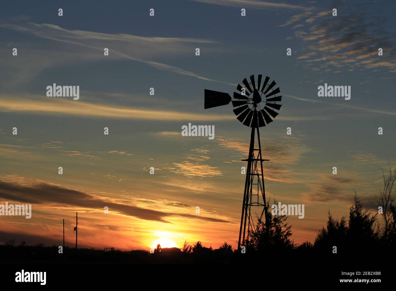 Kansas Sunset with a colorful sky and cloud's with a Windmill and tree ...
