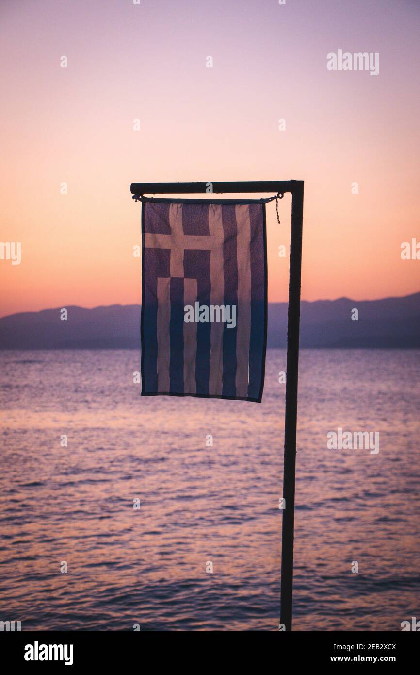 Flag of Greece hanging from a pole gleaming against the sunset Stock ...