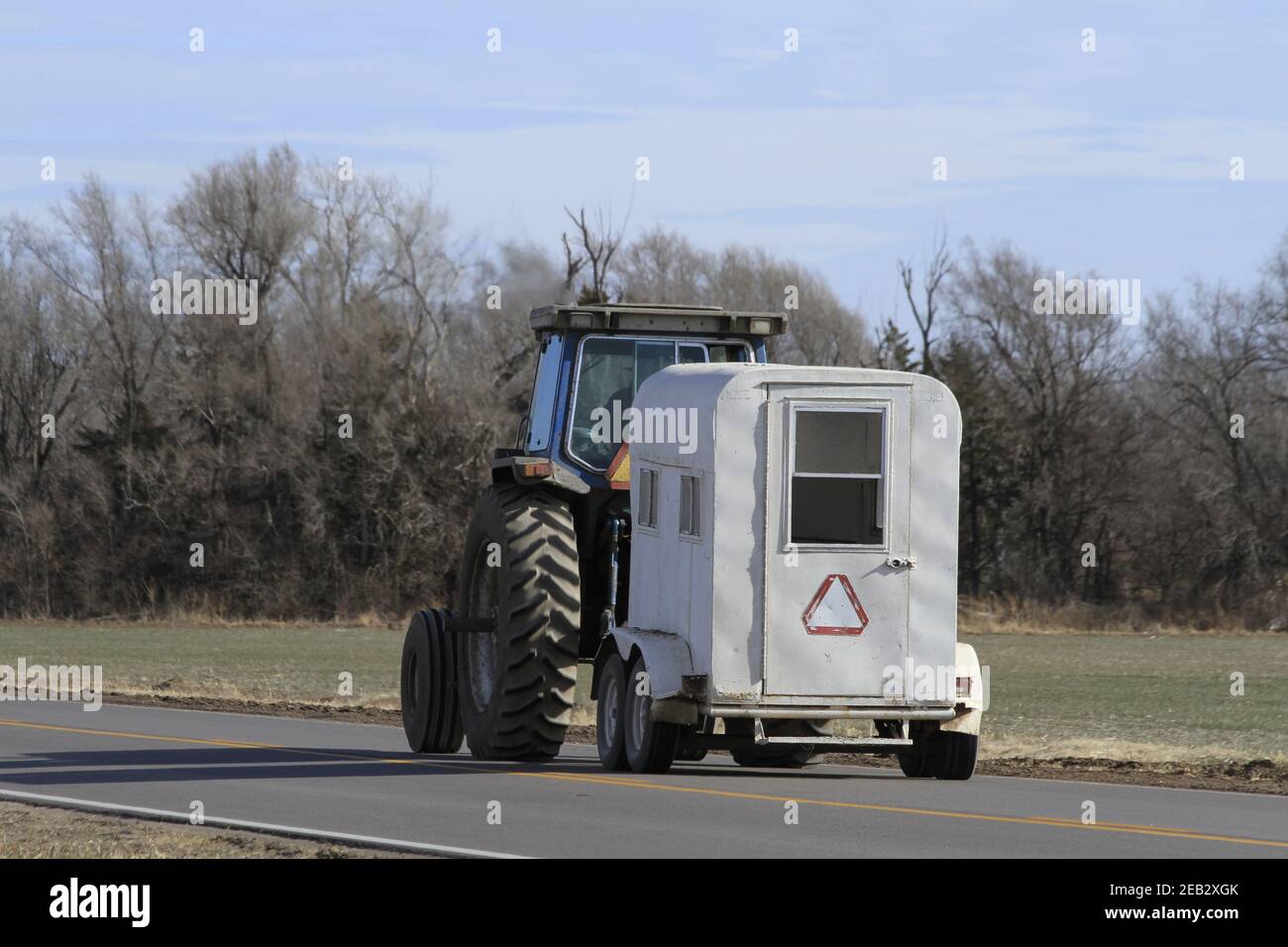 Amish driving a Ford Tractor down the highway pulling a horse trailer ...