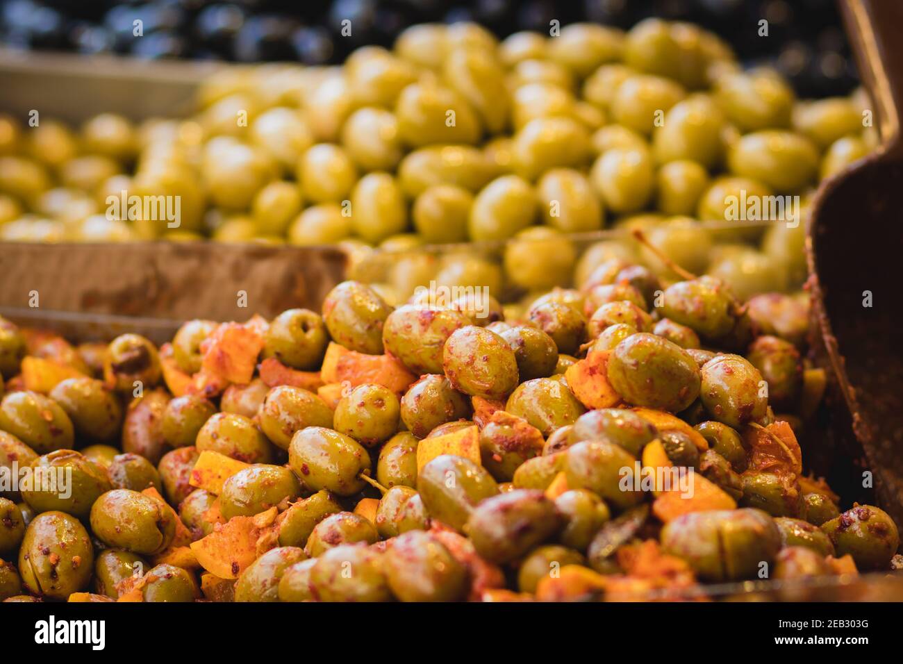 Pile of brown, pickled and seasoned olives in lemon pieces, Israeli ...