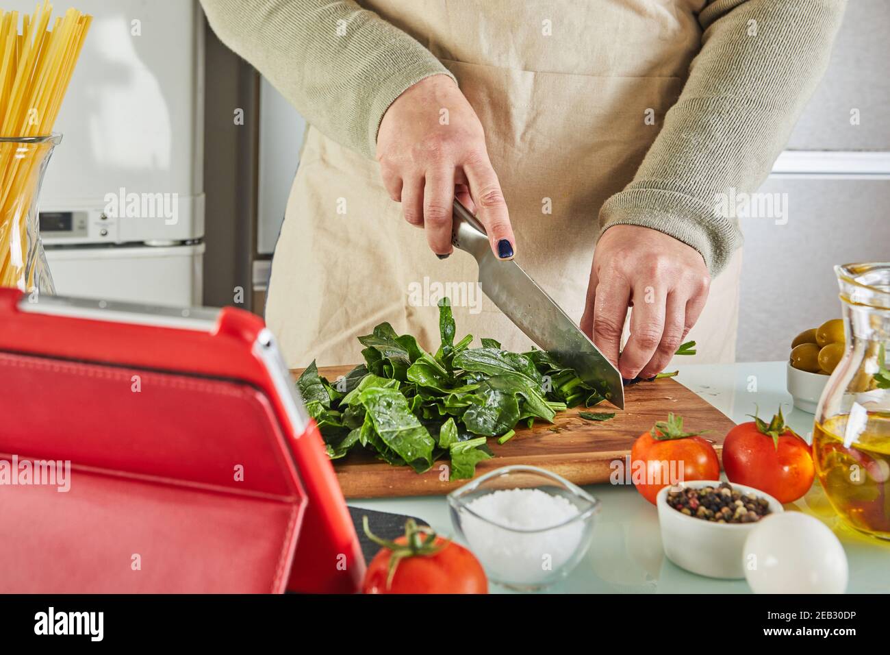 Woman cooking according the tutorial of online virtual master class ...