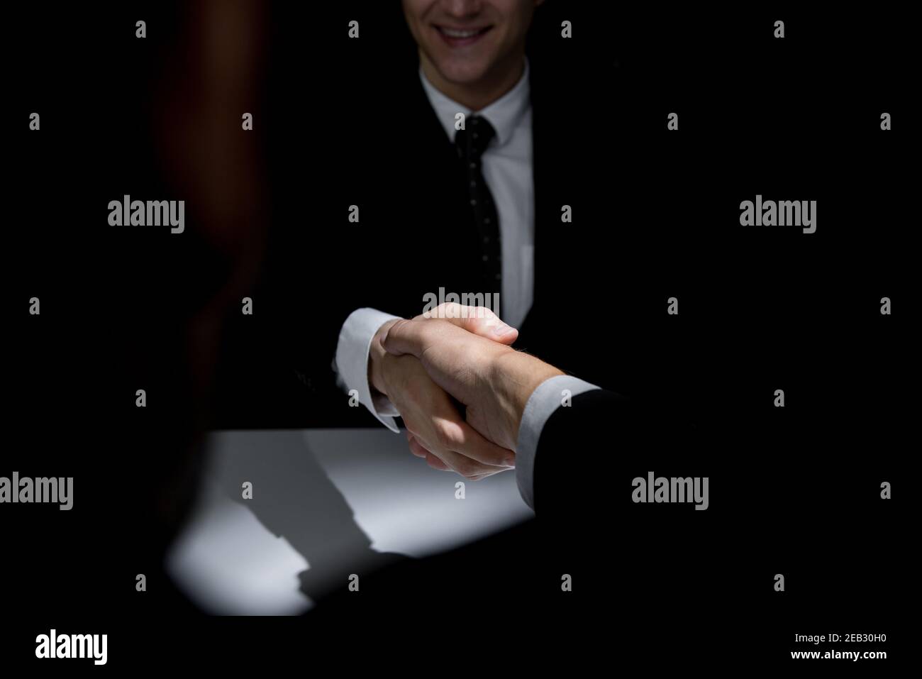 Anonymous business partners making handshake in confidential meeting ...