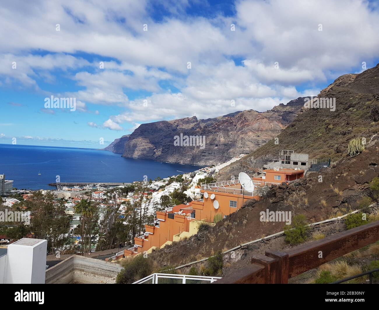 Beautiful scene of Los Gigantes resort town buildings and cliff line in ...
