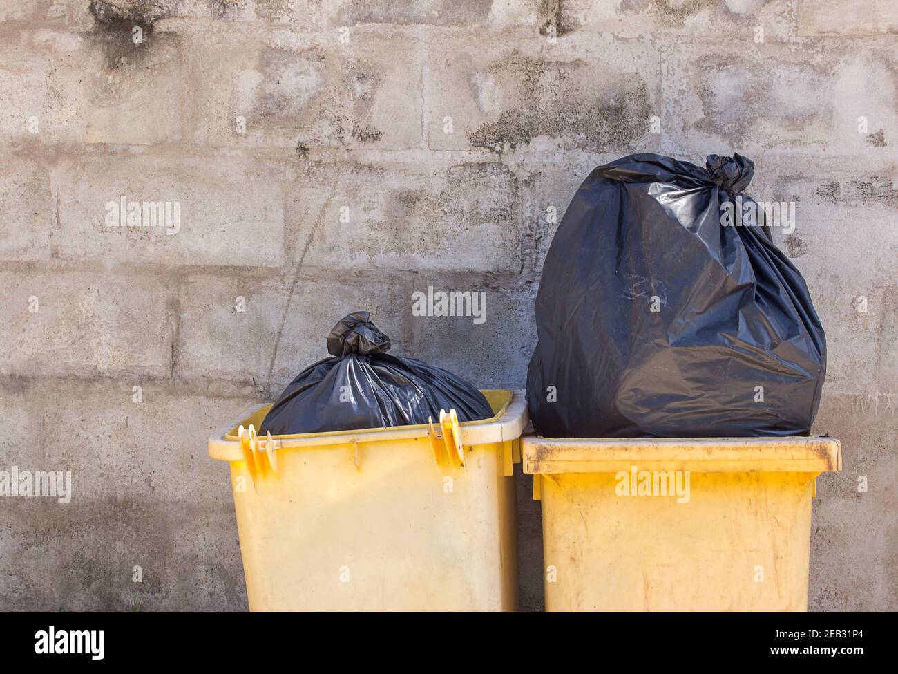 Yellow garbage and trashcan on the street Stock Photo - Alamy