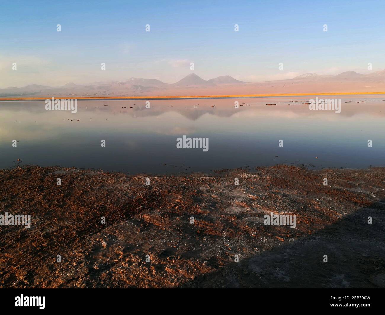 Majestic view of a calm reflective lake with a hazy mountain range on ...