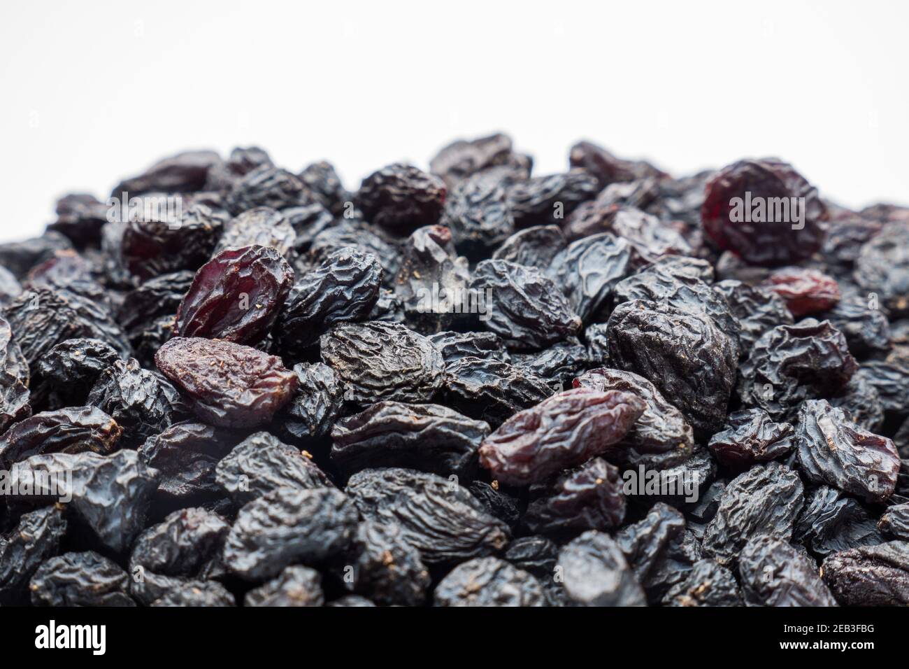 Black raisins on the white background. Vegetarian healthy snack ...