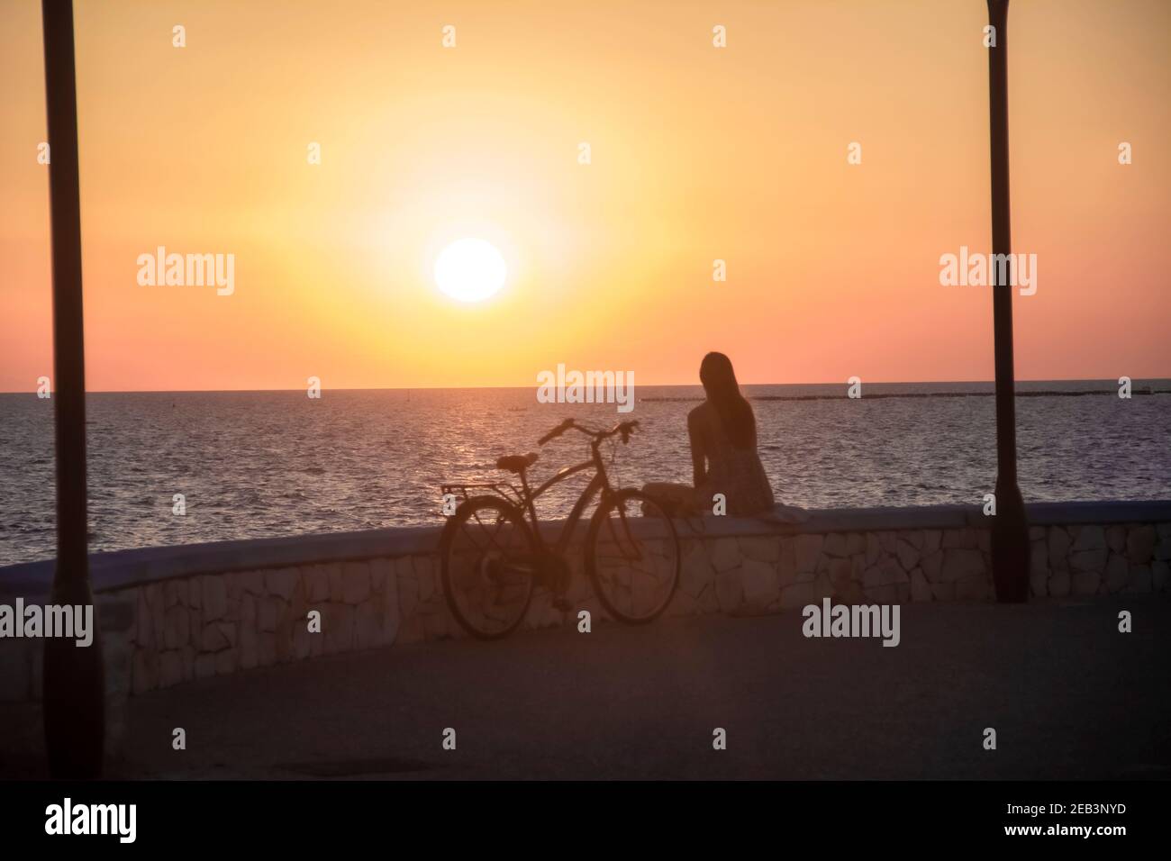 Girl sitting sea sunset hi-res stock photography and images - Alamy