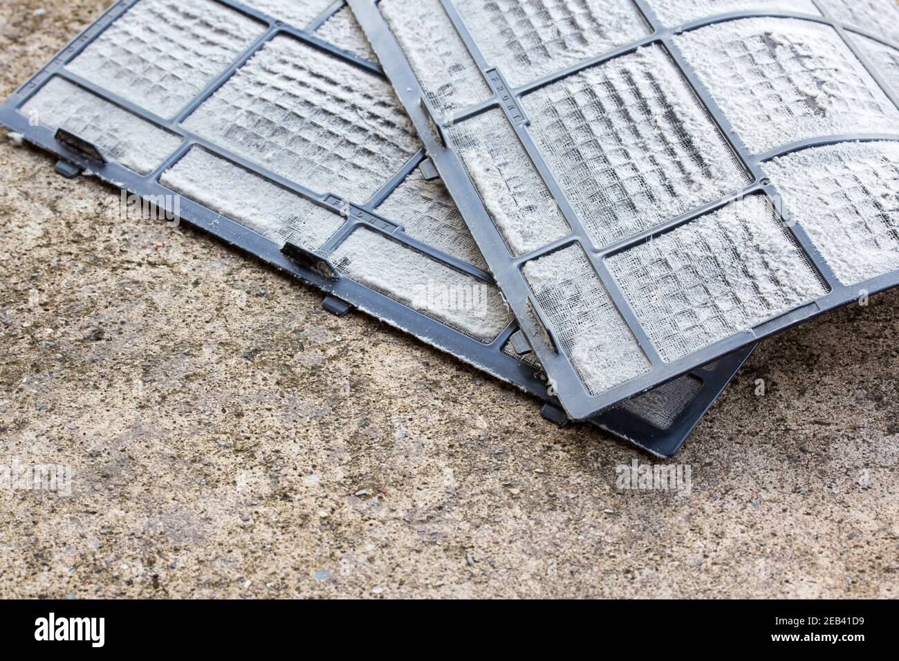 Dirty dust filters of air conditioner ready for cleaning on the ground ...