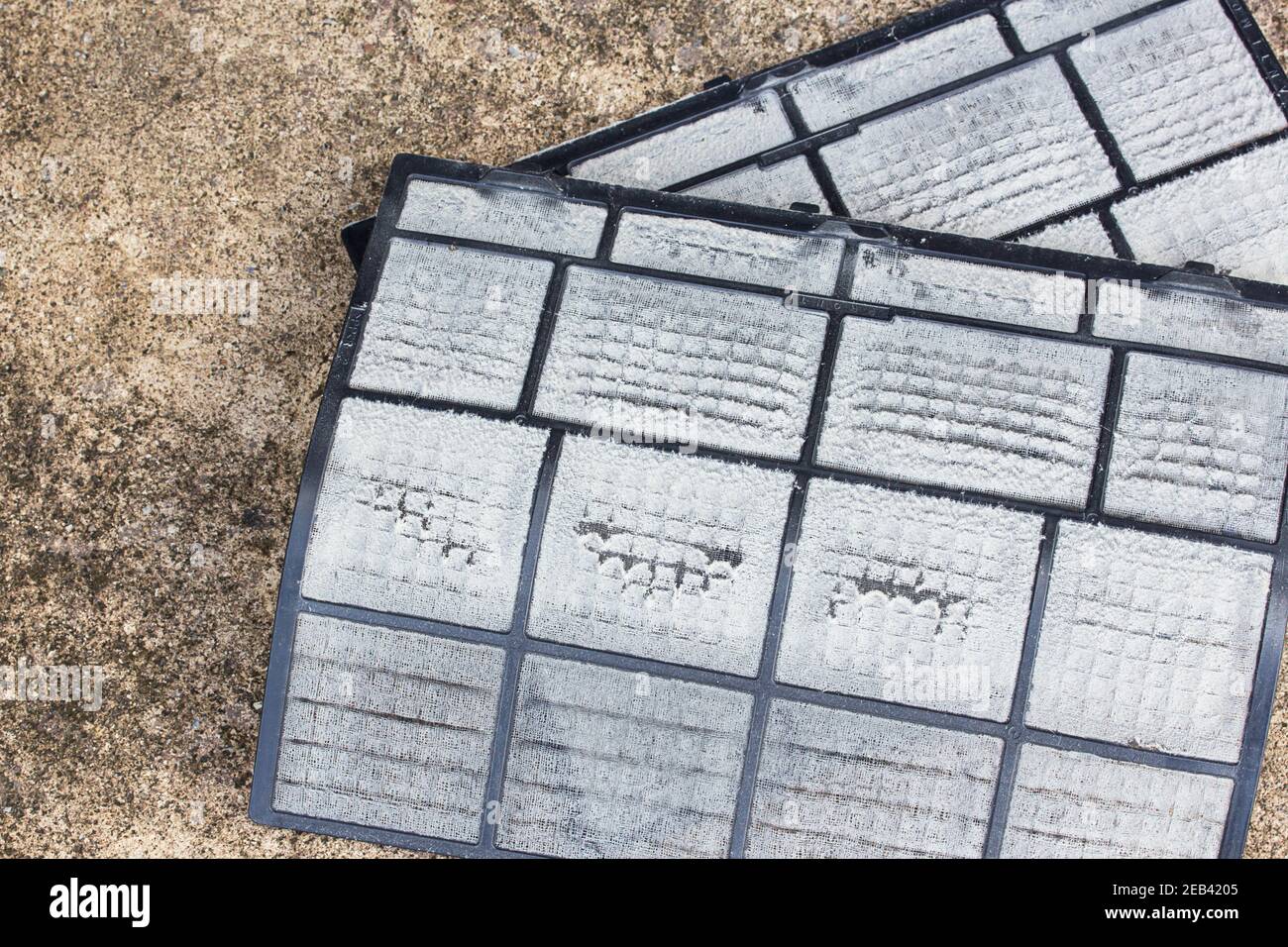 Dirty dust filters of air conditioner ready for cleaning on the ground ...