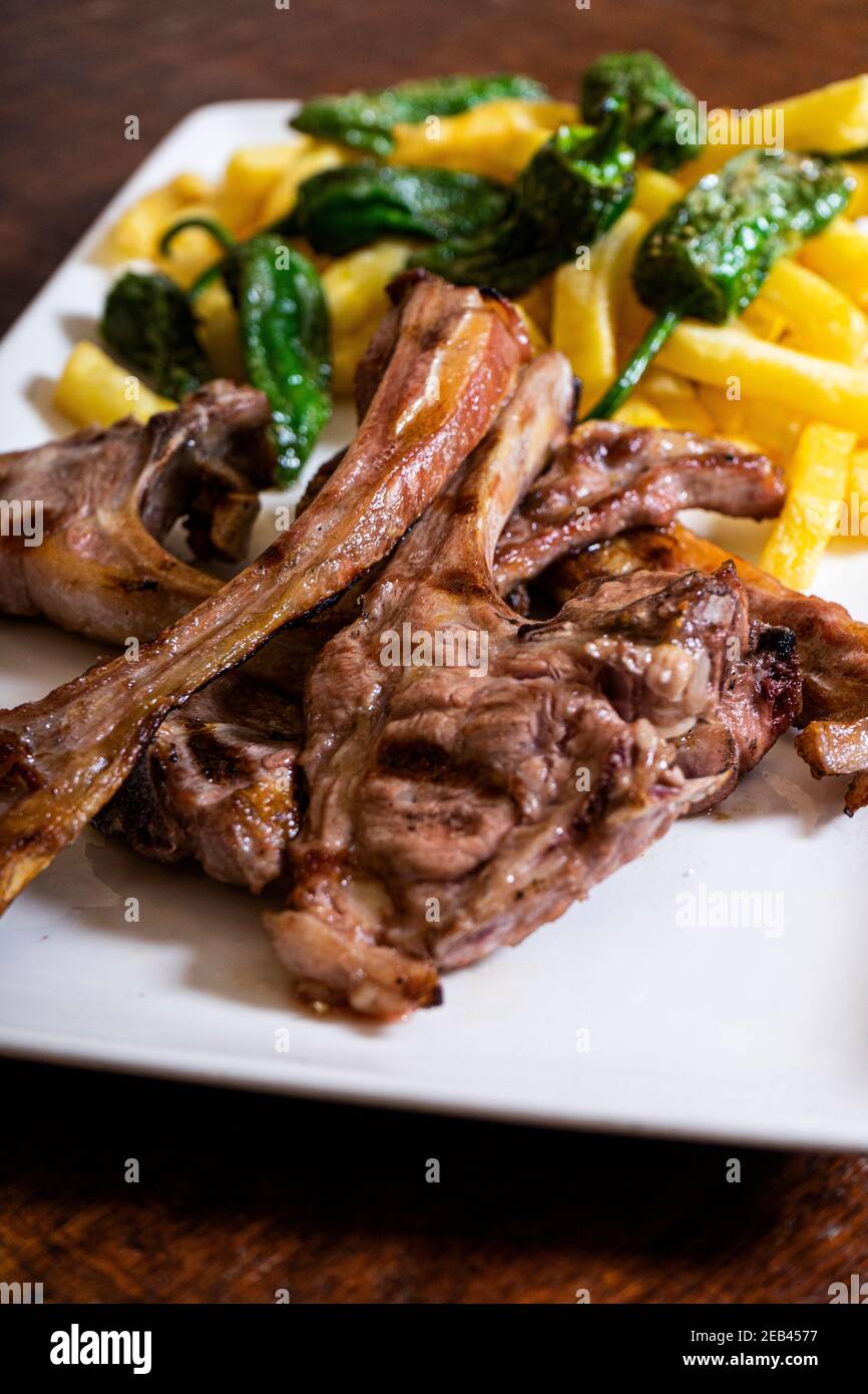 Grilled lamb ribs. Meat served with French fries and peppers. Vertical ...