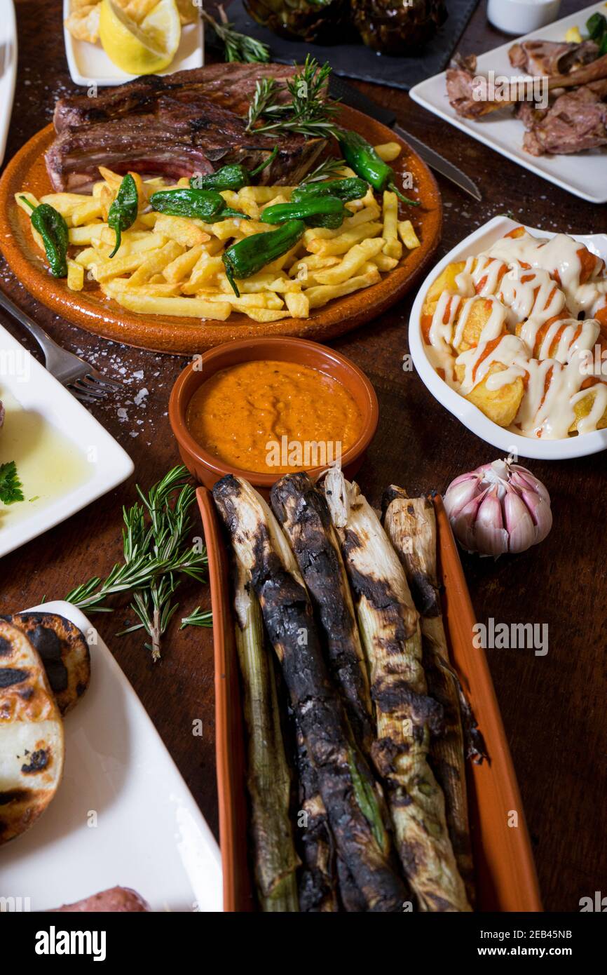 Variety of typical Spanish dishes on wooden table Stock Photo - Alamy
