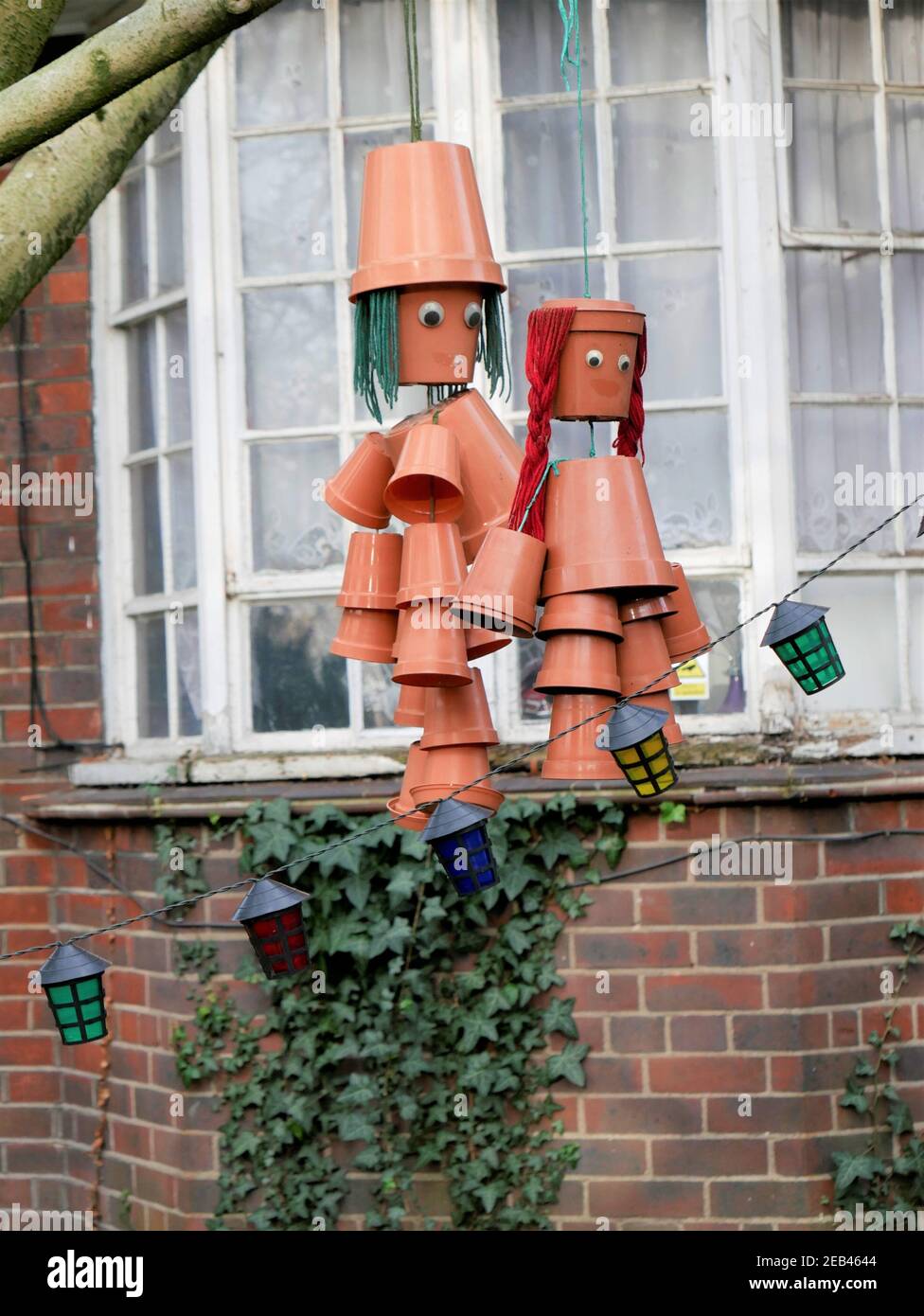Funny flowerpot man hanging from a tree Stock Photo - Alamy