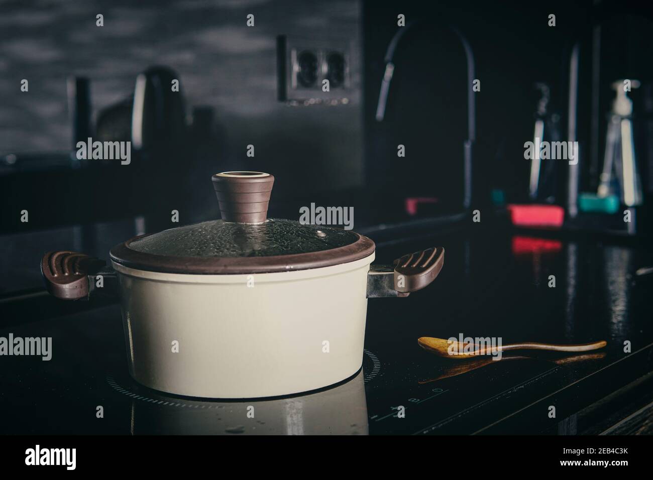 a pot in the kitchen on a black background Stock Photo - Alamy