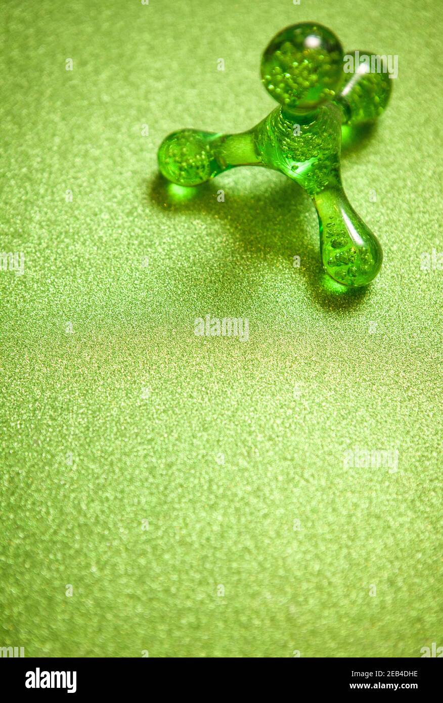 Green massage tool on glitter green background Stock Photo - Alamy