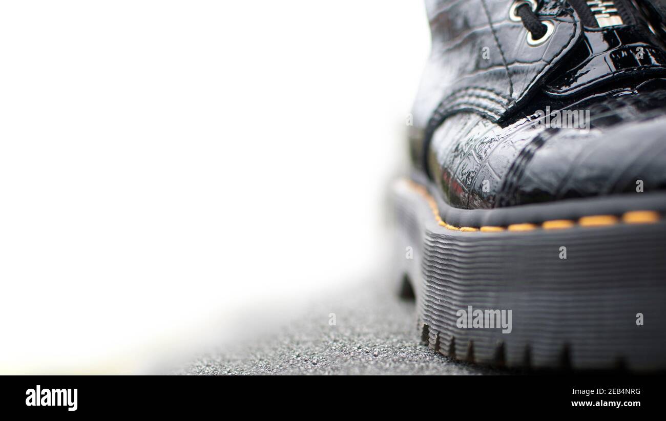 Front view of part of a shiny black shoe with high rubber sole and ...