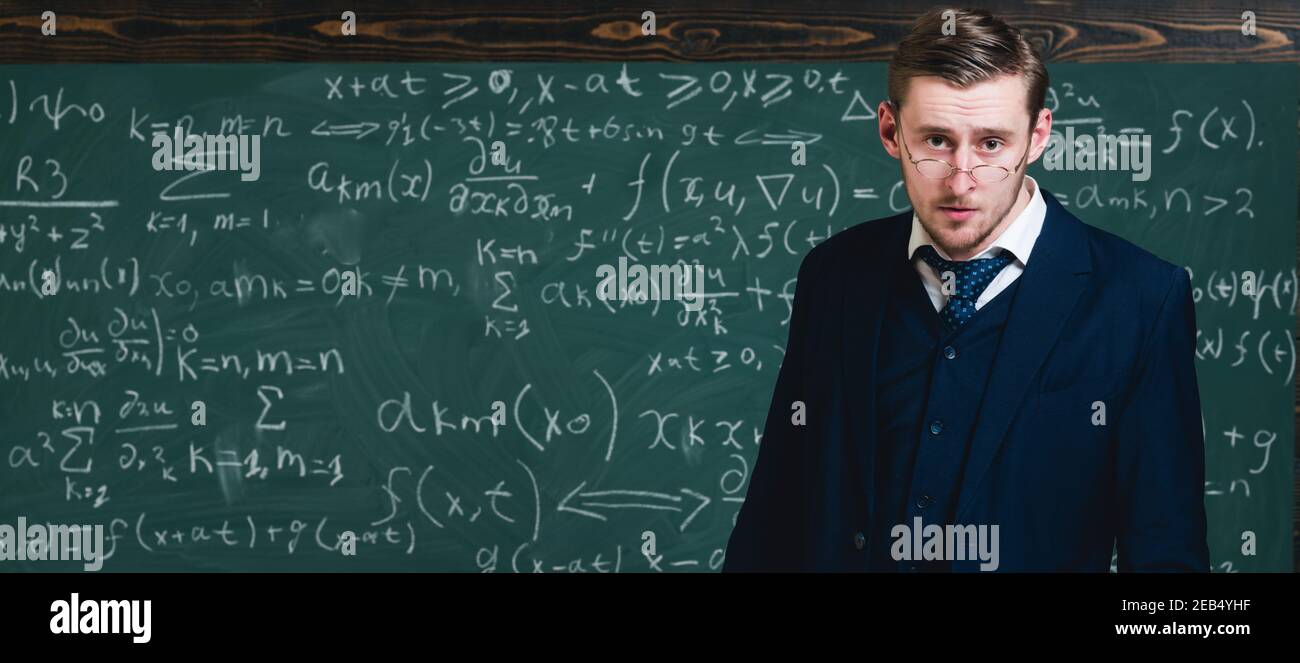 Intelligent teacher in suit and glasses. Young professor explaining ...