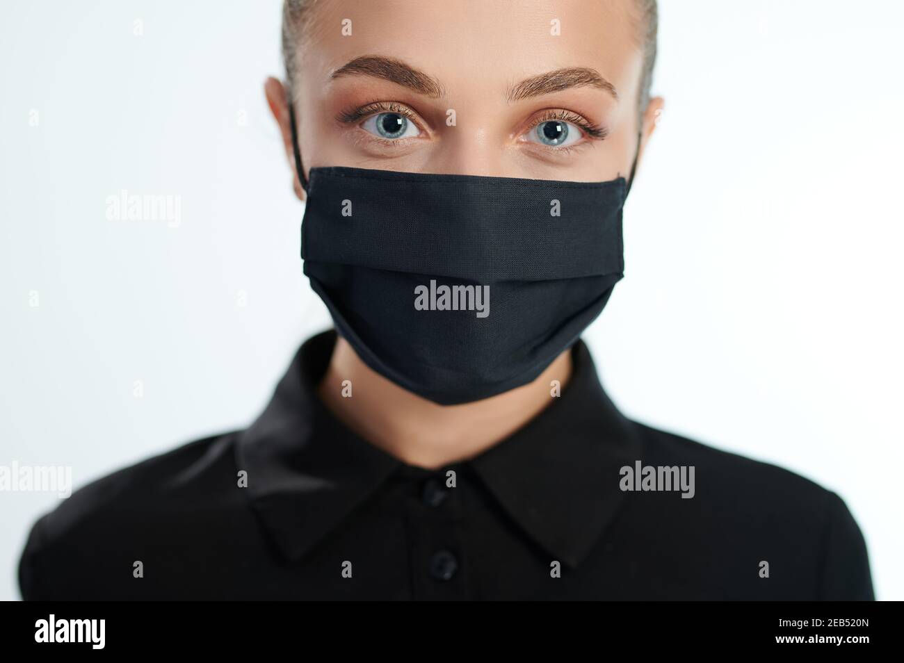 Young woman in black face mask close up view isolated on white ...