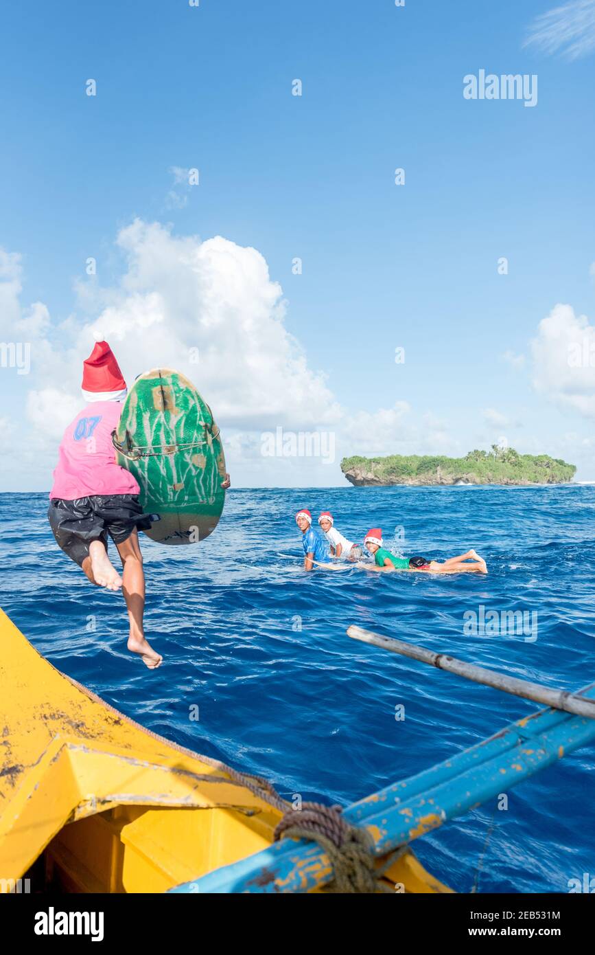 Surfers Kids Jumping into the Ocean for Surf Stock Photo - Alamy