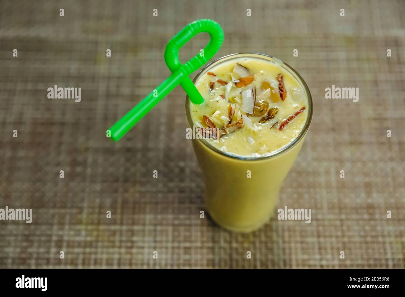 Homemade Fresh Mango Lassi with Nuts and Straw on the table. Sweet ...
