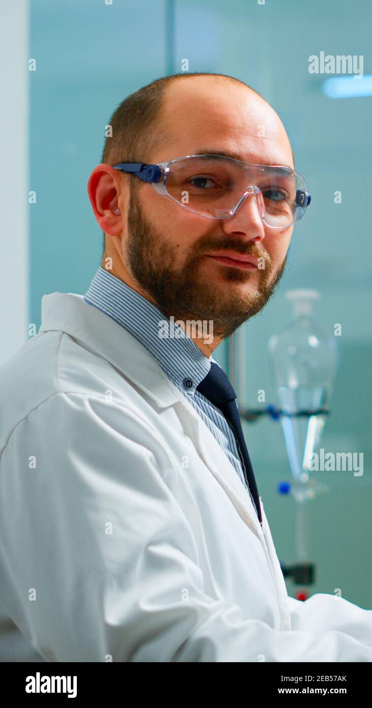 Portrait of scientist man looking at camera sitting in modern equipped ...