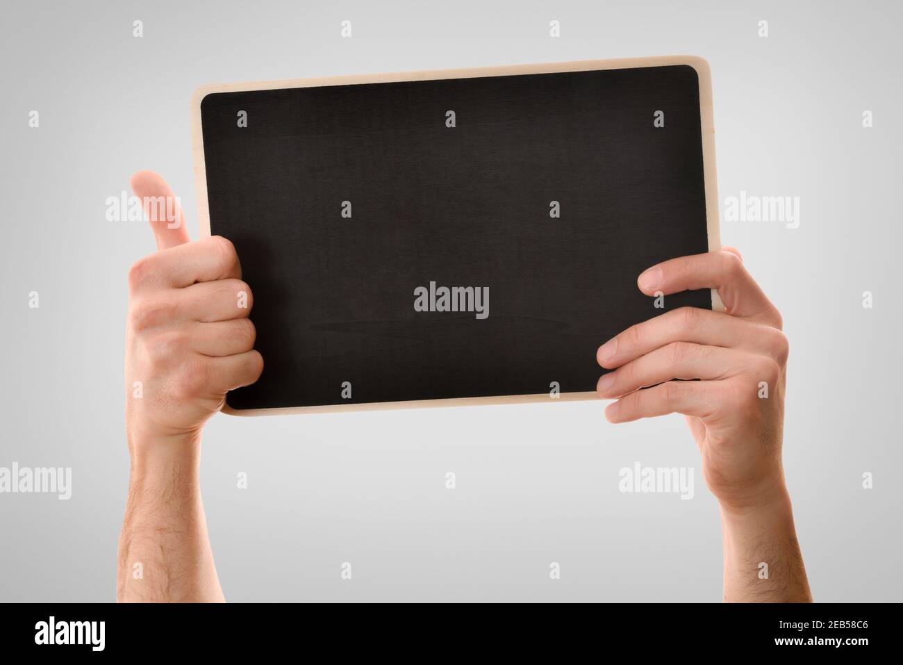 Two hands with ok sign catching blackboard horizontally with isolated ...