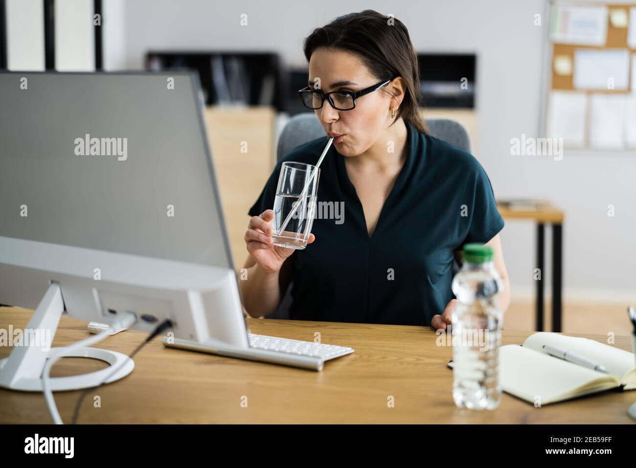 Woman Drinking Water From Glass On Desk While Using Computer Stock ...