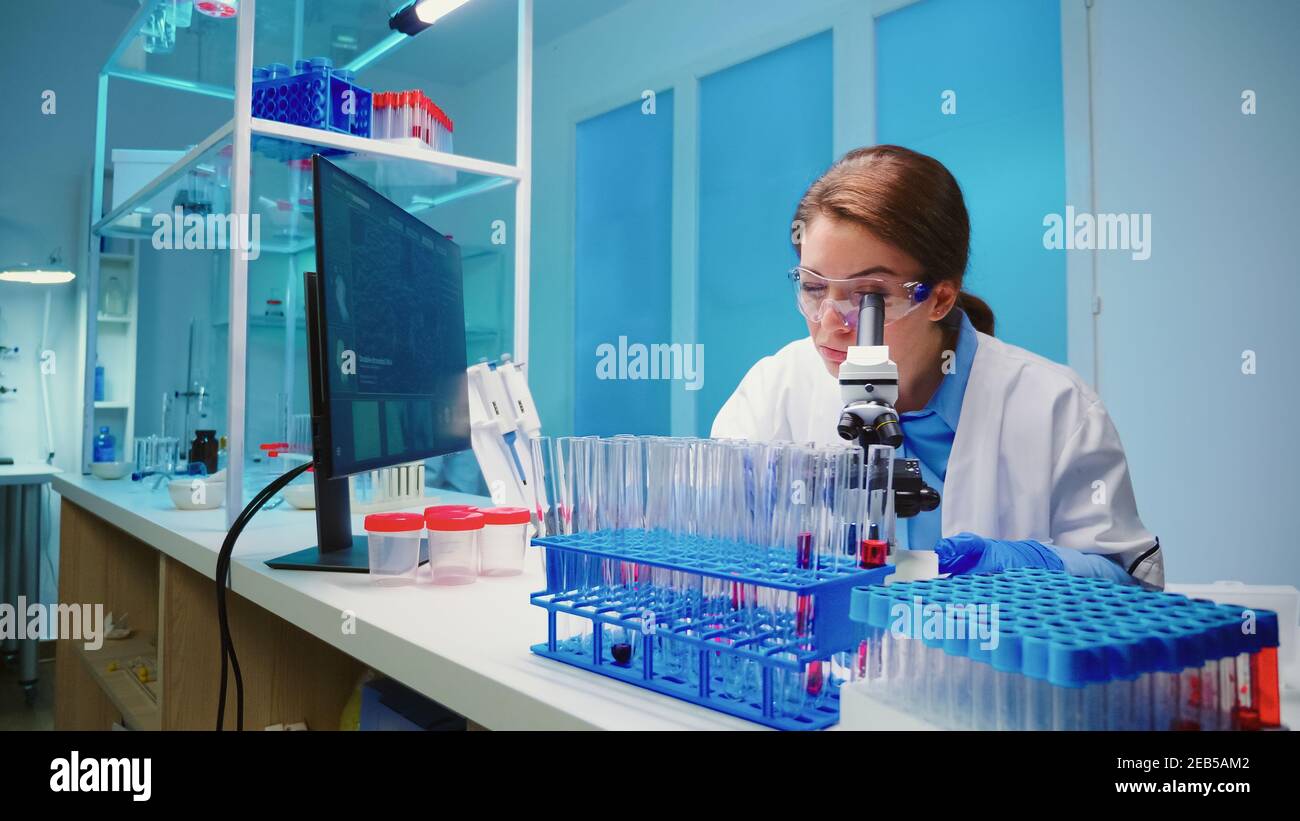 Team of scientist checking virus development using microscope analysing ...