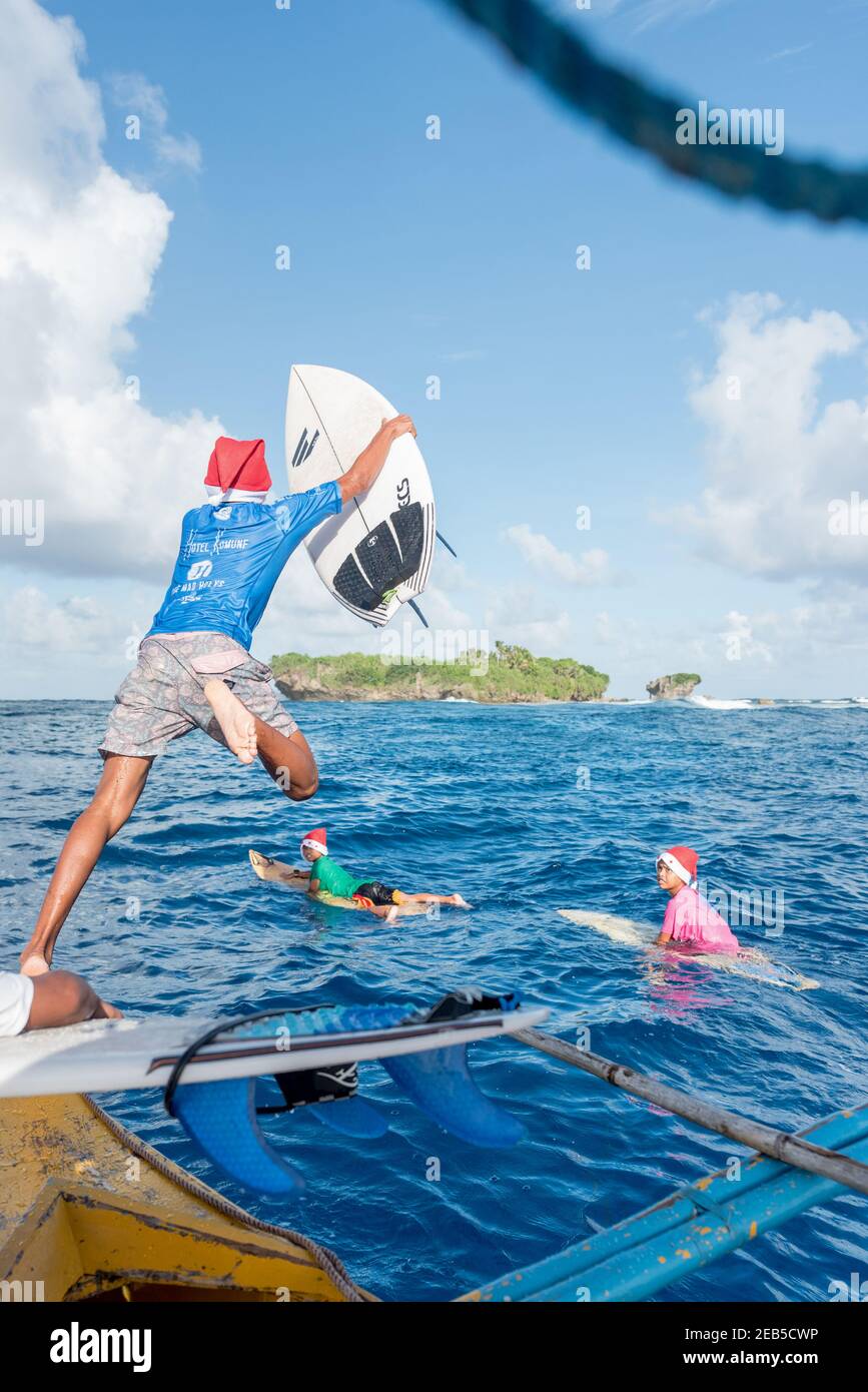 Surfers Kids Jumping into the Ocean for Surf Stock Photo - Alamy