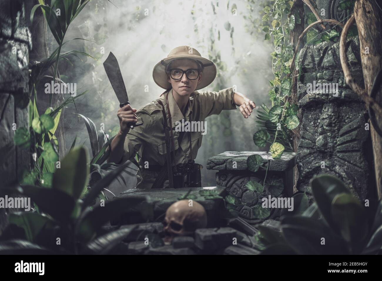 Vintage adventurer exploring the jungle and holding a machete, she ...