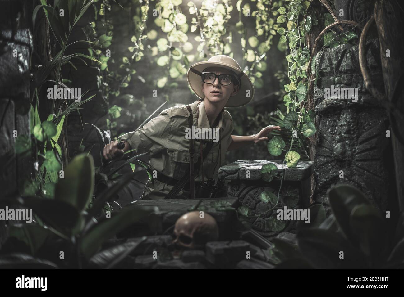 Vintage adventurer exploring the jungle and holding a machete, she ...