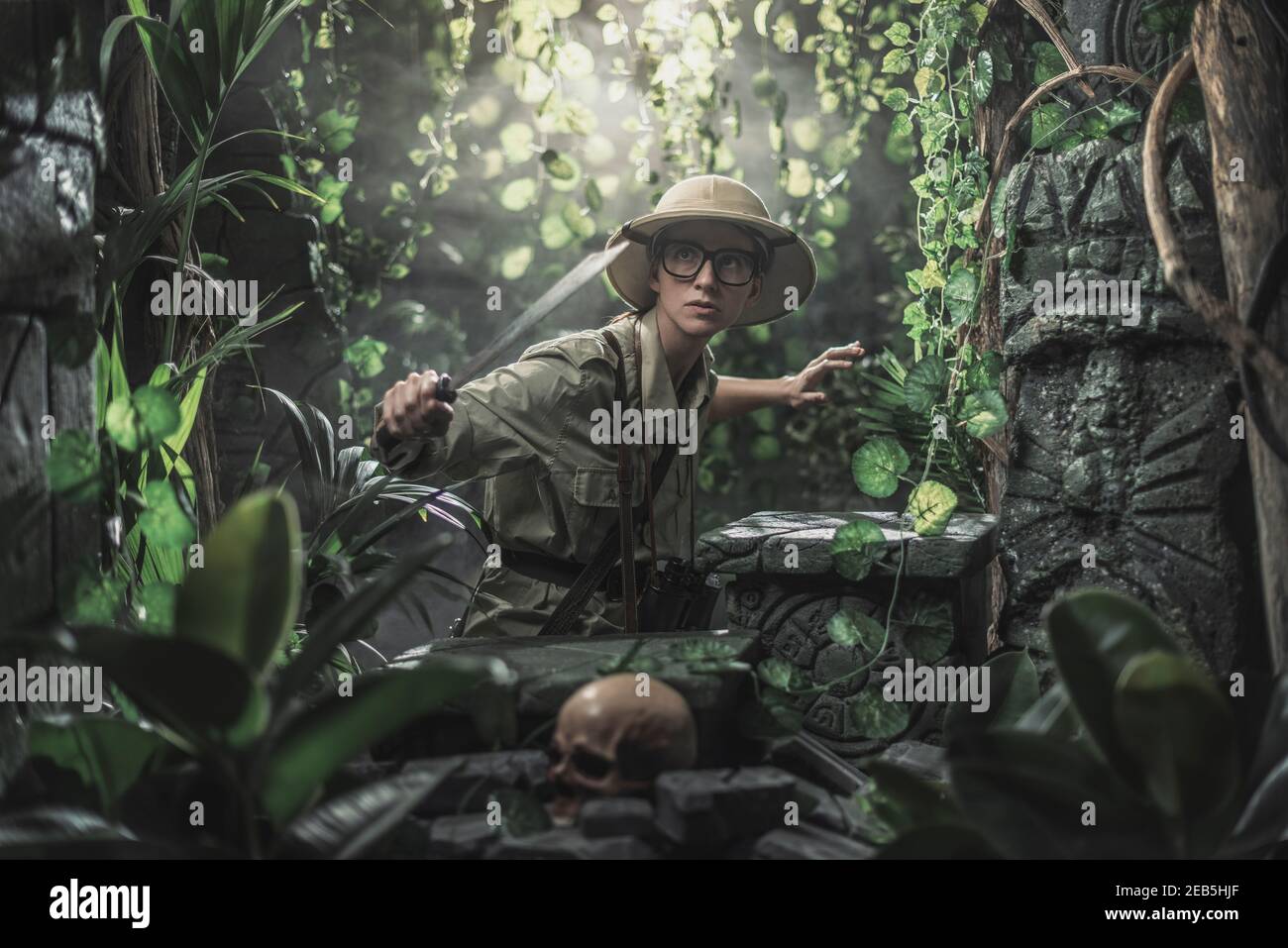 Vintage adventurer exploring the jungle and holding a machete, she ...
