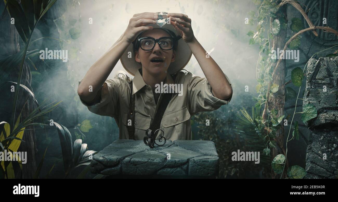 Happy explorer finding a precious treasure in the tropical jungle, she ...