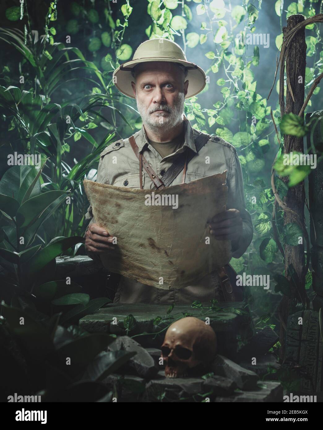 Vintage explorer holding an ancient map and walking in the forest Stock ...