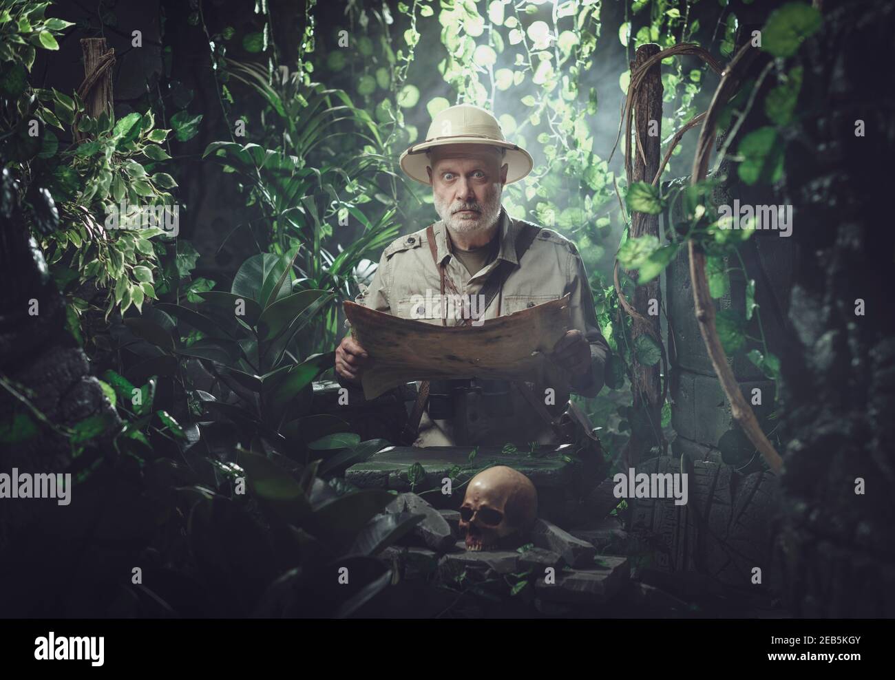 Vintage explorer holding an ancient map and walking in the forest Stock ...