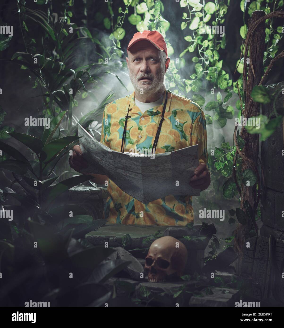 Funny scared tourist lost in the tropical jungle, he is holding a map ...