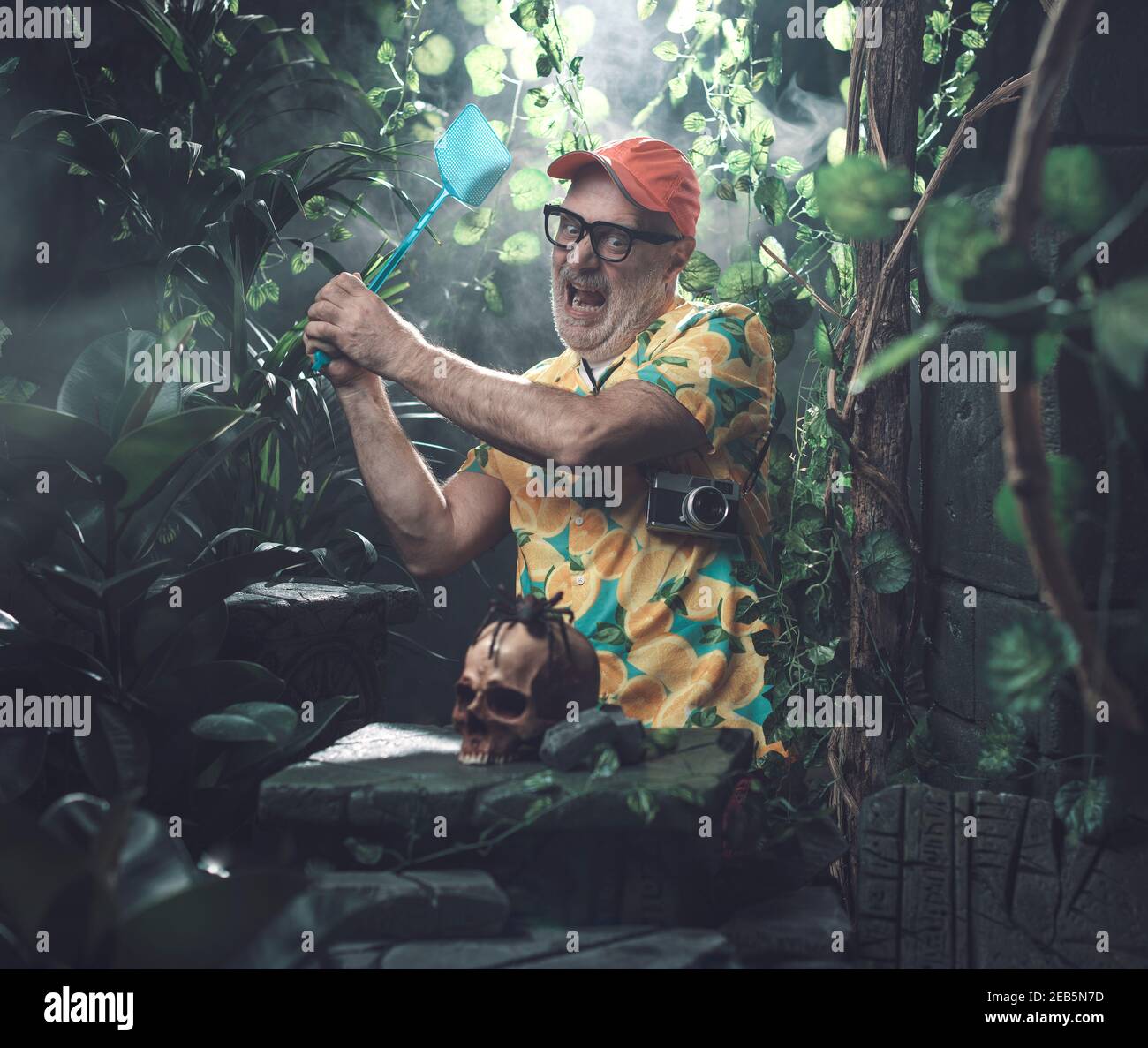 Angry tourist trying to kill a huge spider in the forest using a fly ...