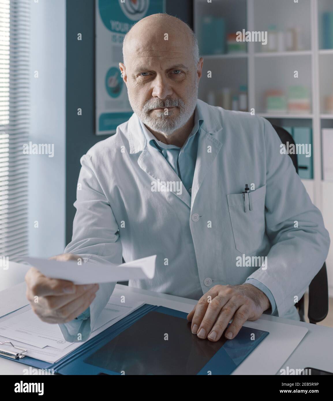 Professional doctor working in his office, he is giving a prescription ...