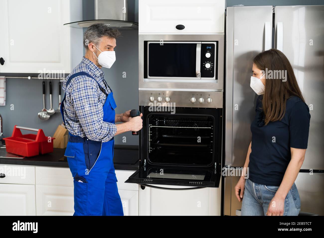 Oven Appliance Appliance In Kitchen By Handyman In Face Mask Stock ...