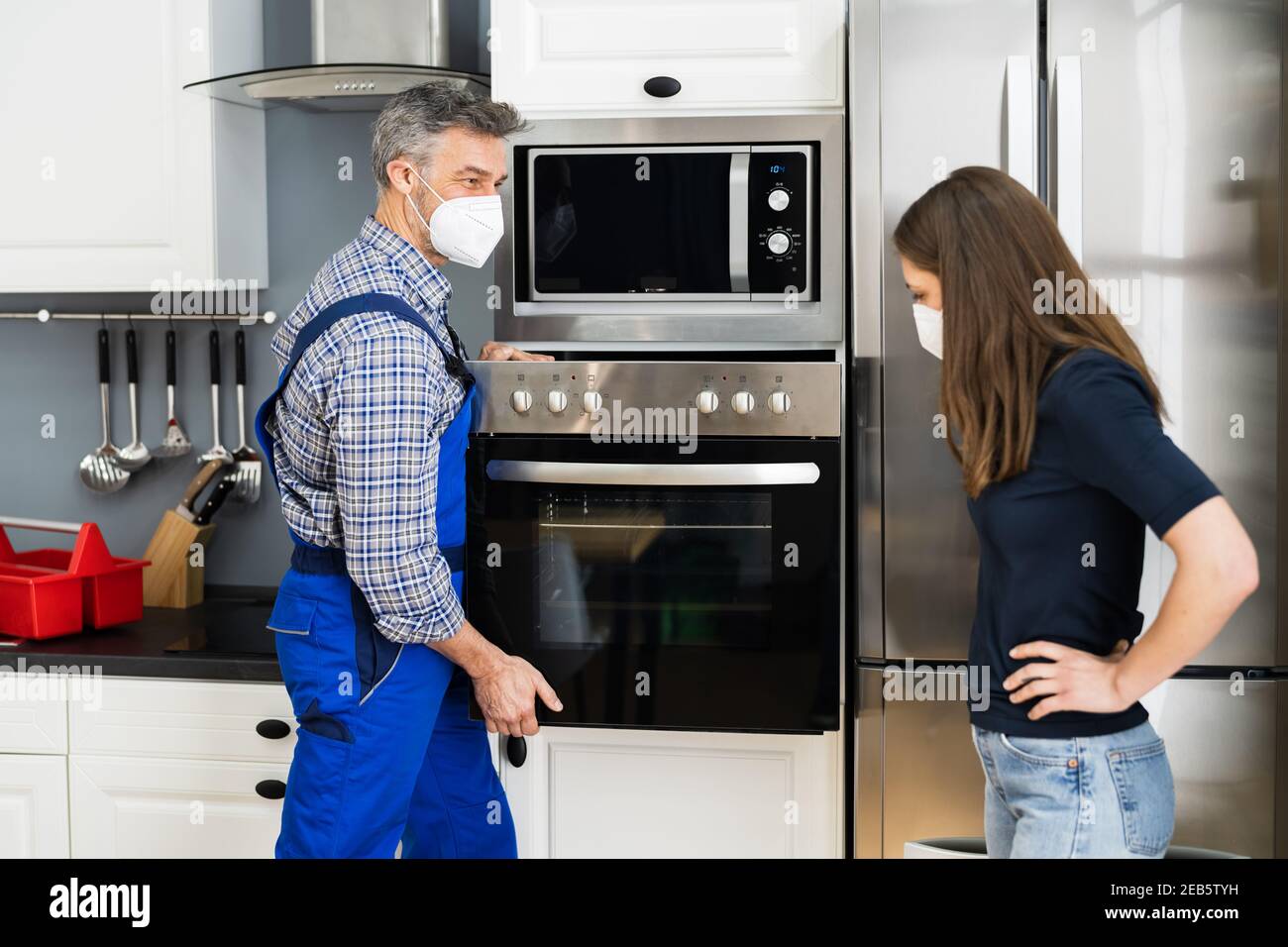 Oven Appliance Appliance In Kitchen By Handyman In Face Mask Stock ...