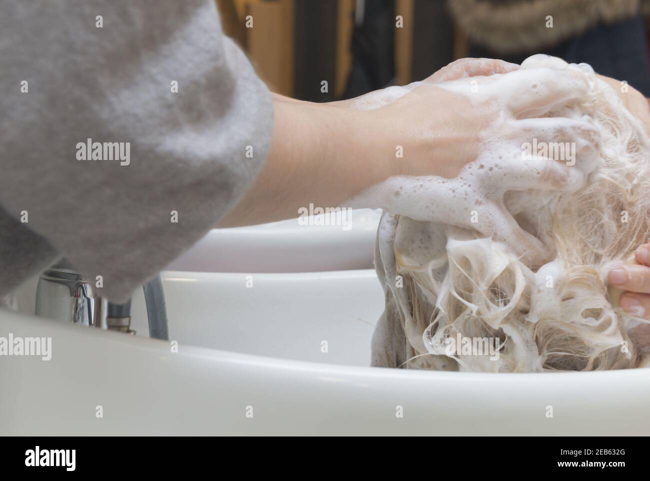 Stylist lathering the client's hair with shampoo Stock Photo - Alamy